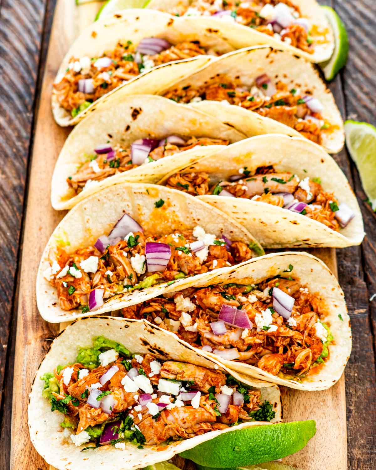 A Row Of Chicken Tinga Tacos On A Cutting Board A Row Of Chicken Tinga Tacos On A Cutting Board